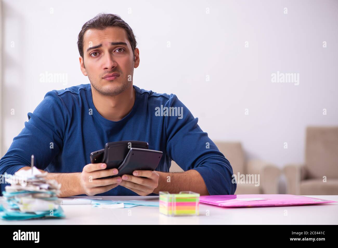 Young man in the budget planning concept Stock Photo - Alamy