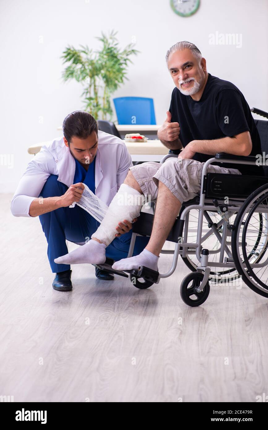 Old injured man visiting young doctor traumatologist Stock Photo - Alamy