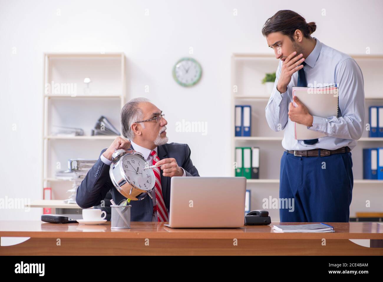 Old boss and young employee in the office Stock Photo - Alamy