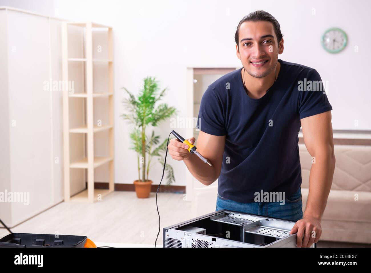 Young man repairing computer at the home Stock Photo - Alamy