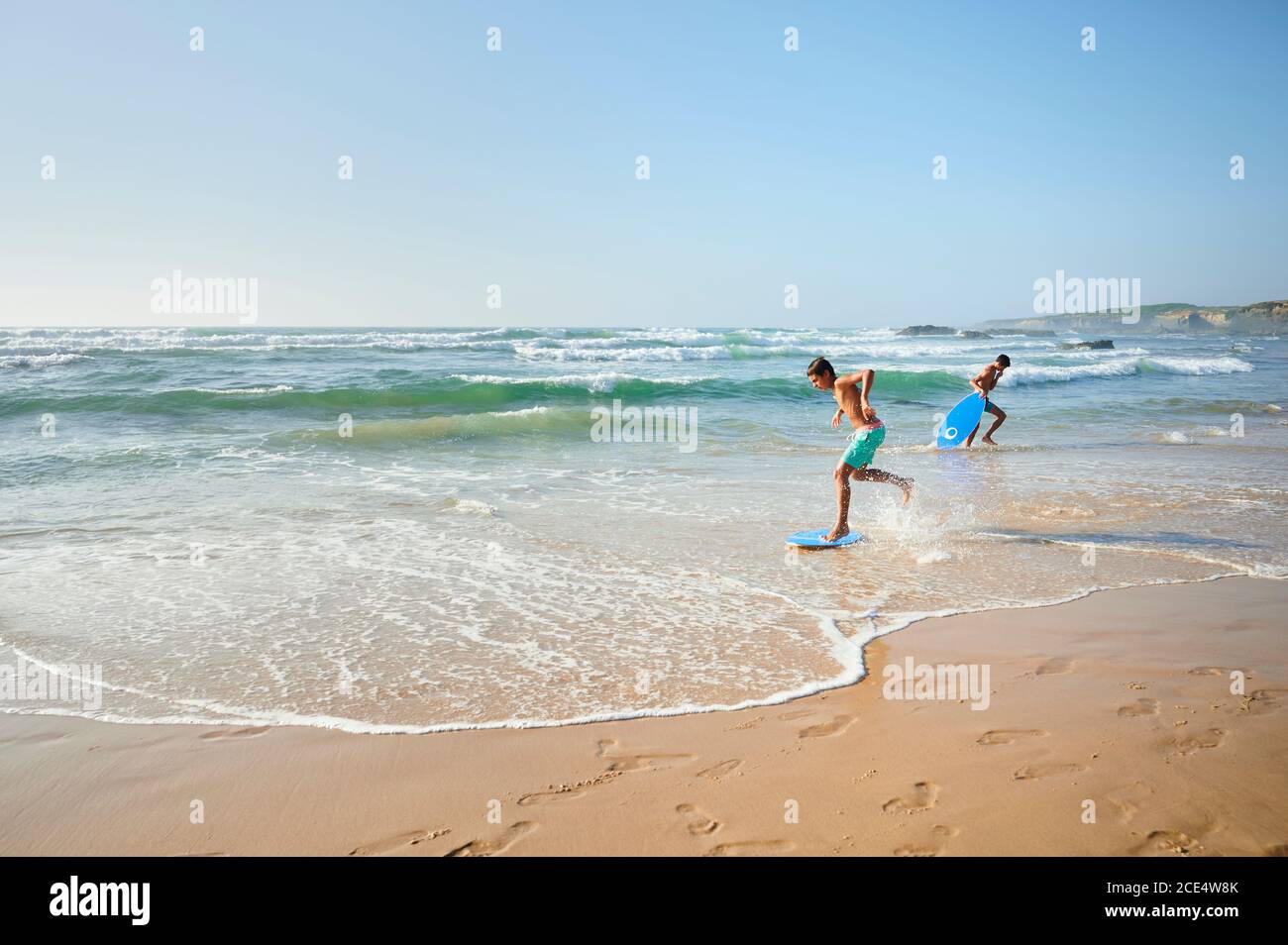 Young boy doing skimming on the beach Stock Photo - Alamy