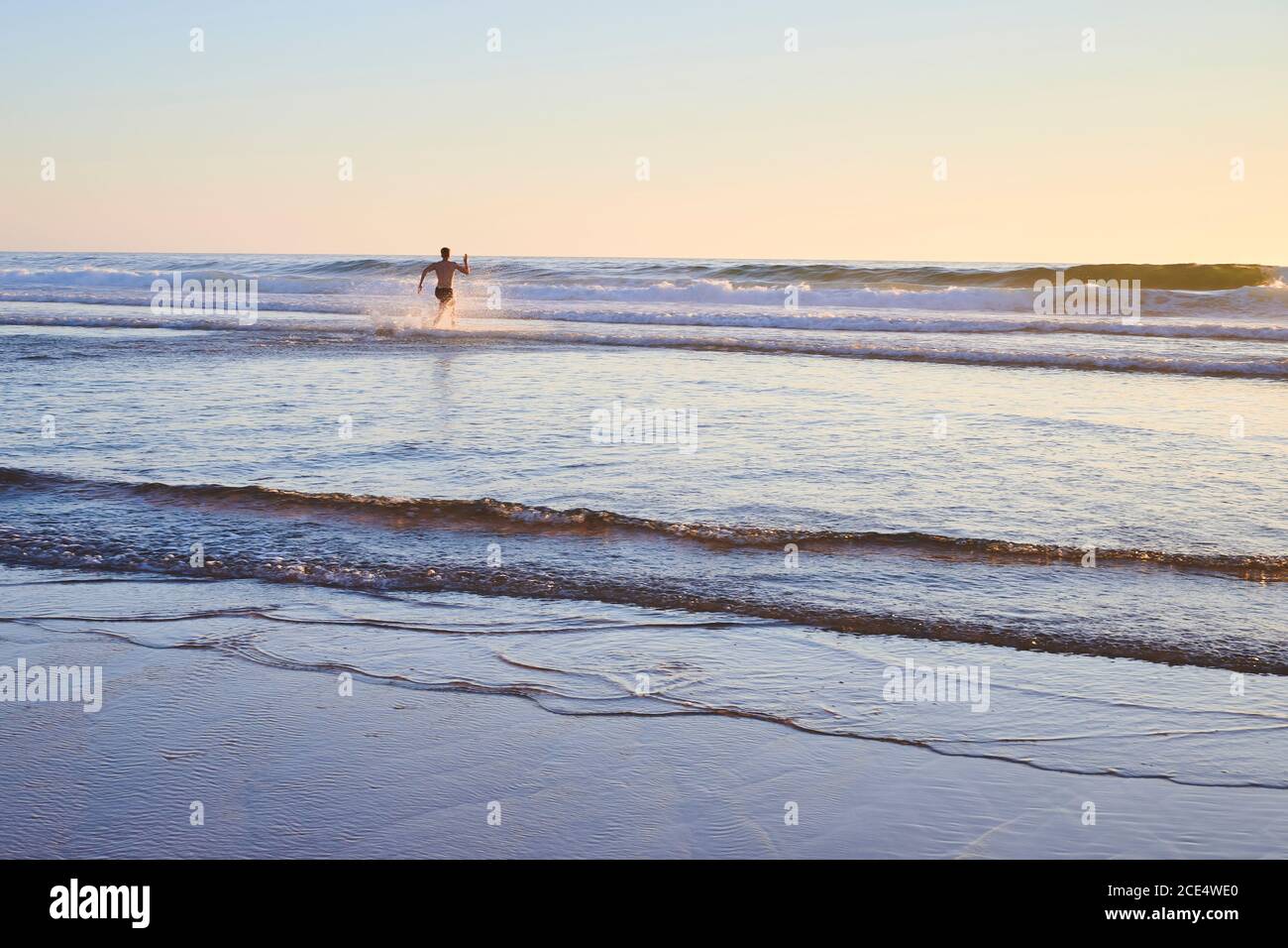 Man running into waves hi-res stock photography and images - Alamy