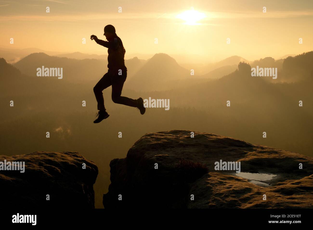Crazy hiker jump between cliffs. Amazing mountains, heavy mist Stock ...