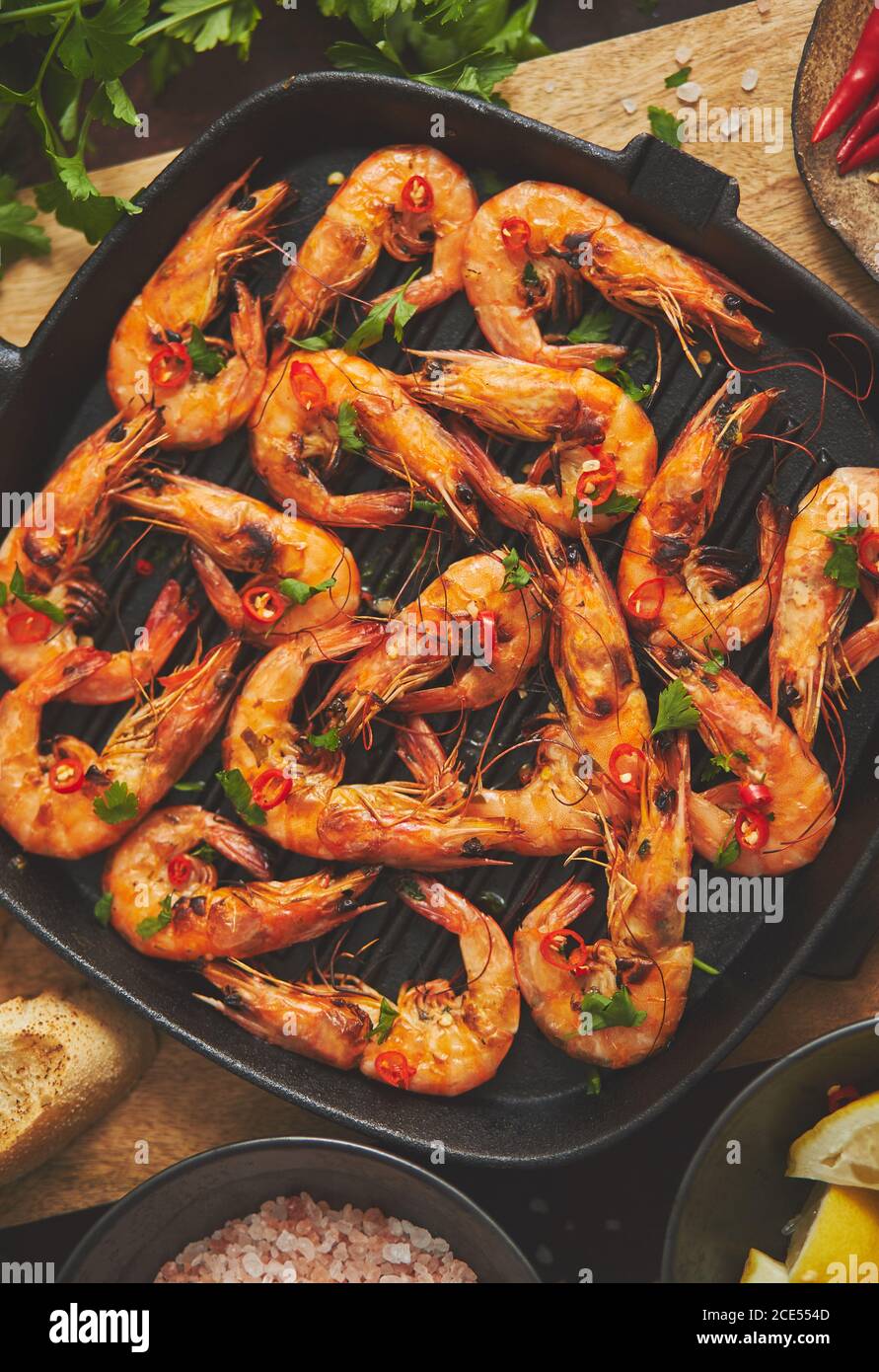Roasted tiger prawns on iron grilling pan with fresh persley, lemon ...