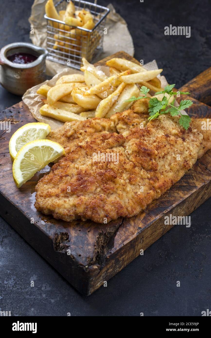 Fried Wiener schnitzel from veal topside with French fries and lemon ...