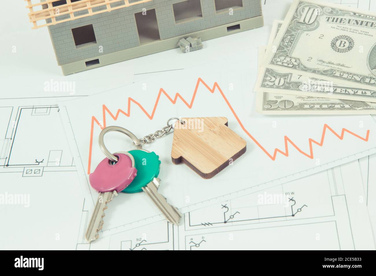 Keys of home, currencies dollars and downward graphs on electrical ...