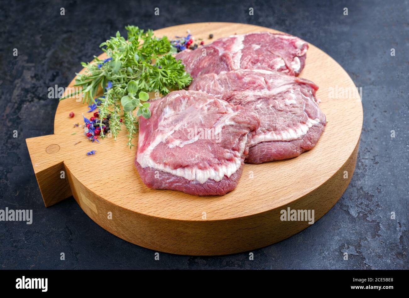 Traditional German raw beef cheeks offered as closeup with herb and ...