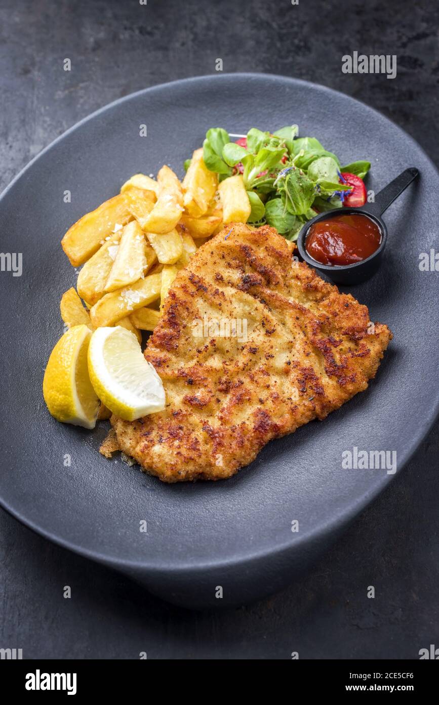 Fried Wiener schnitzel from veal topside with French fries and lettuce ...