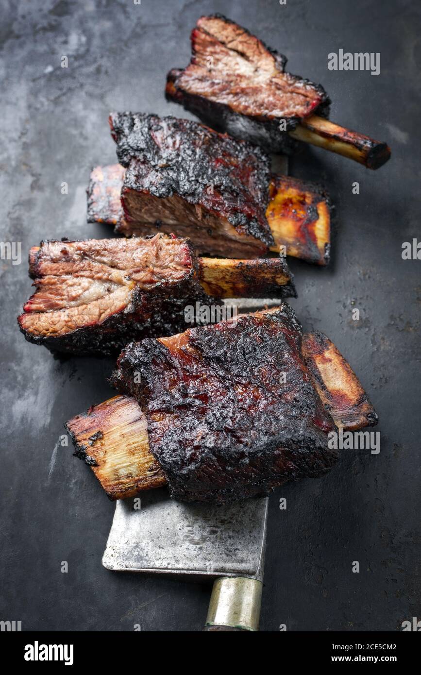 Barbecue burnt chuck beef ribs with hot rub as closeup on a knife on a ...