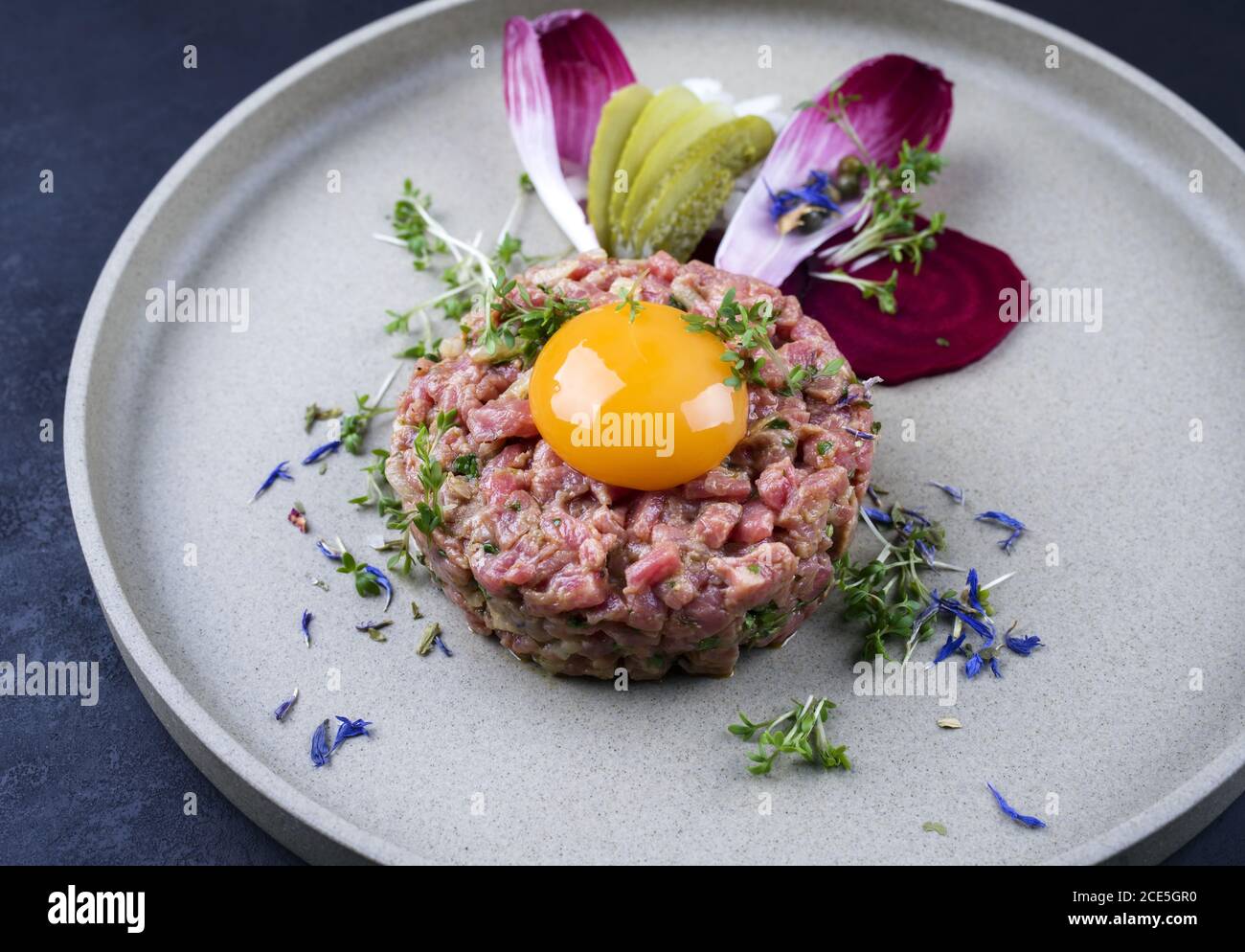 Gourmet tartar raw from beef fillet with yellow of the egg and ...