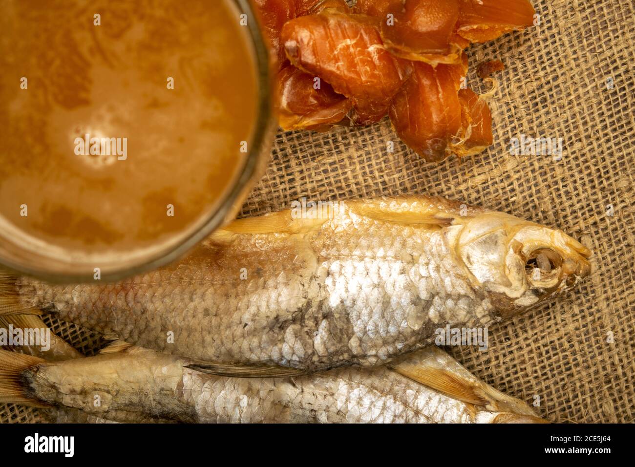Dried fish, dried caviar and a beer mug on a homespun cloth with a ...