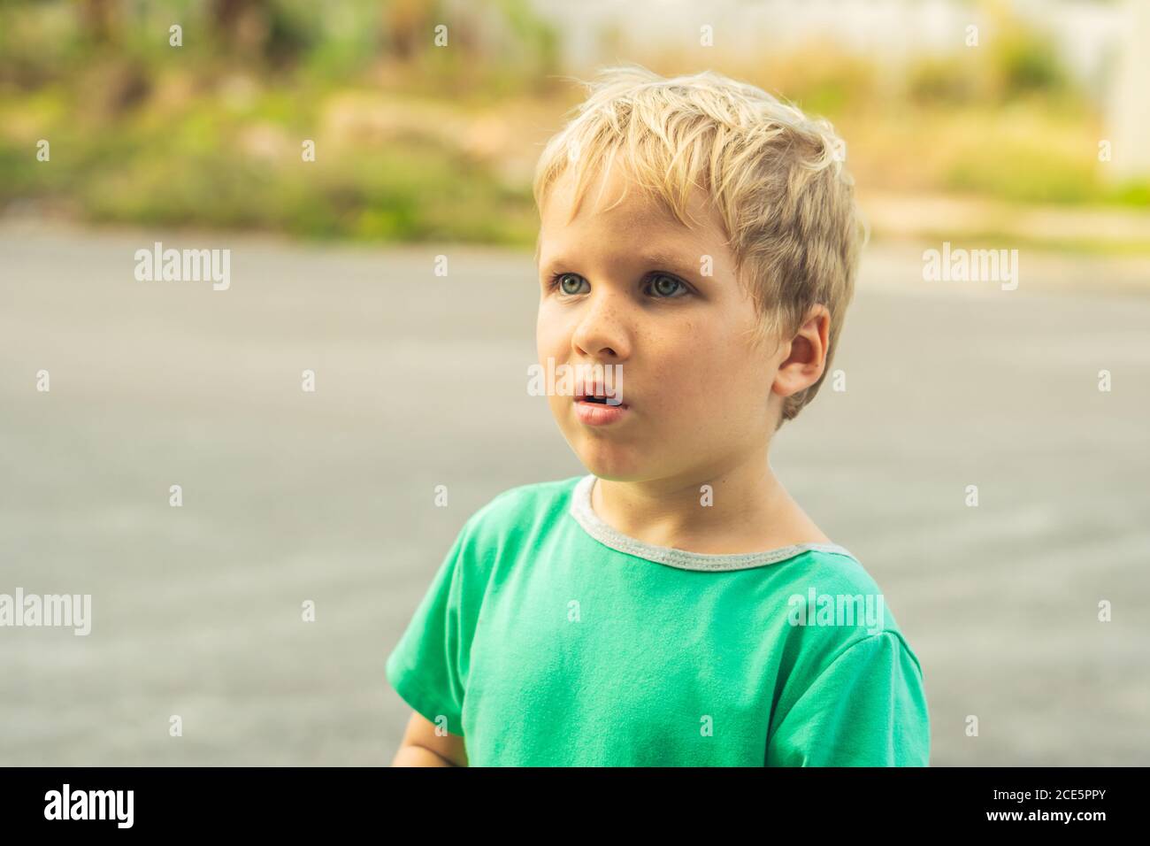 Portrait blond serious sad boy with freckles surprised, waiting look ...