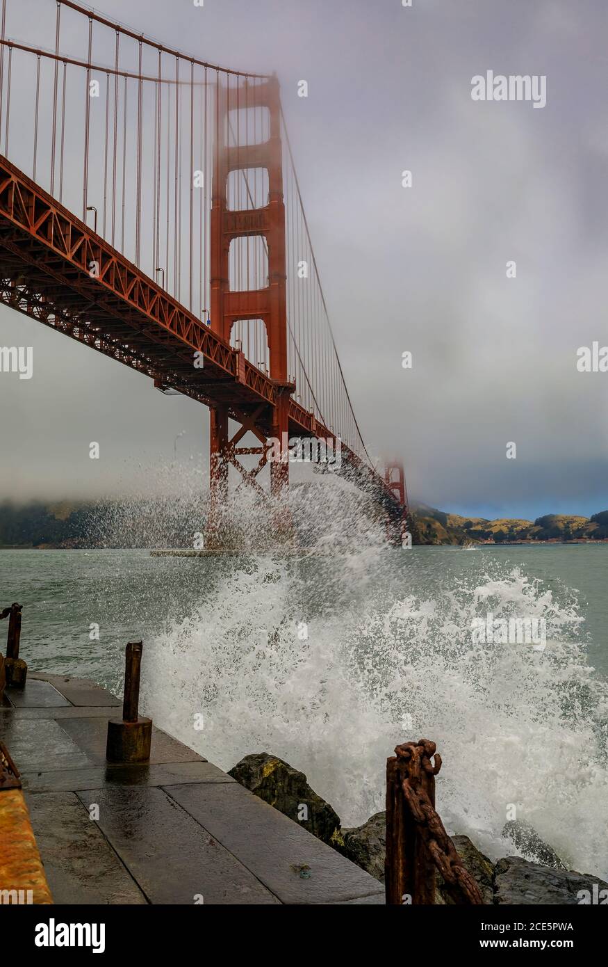 Waves crashing at the famous Golden Gate bridge on a cloudy summer day ...