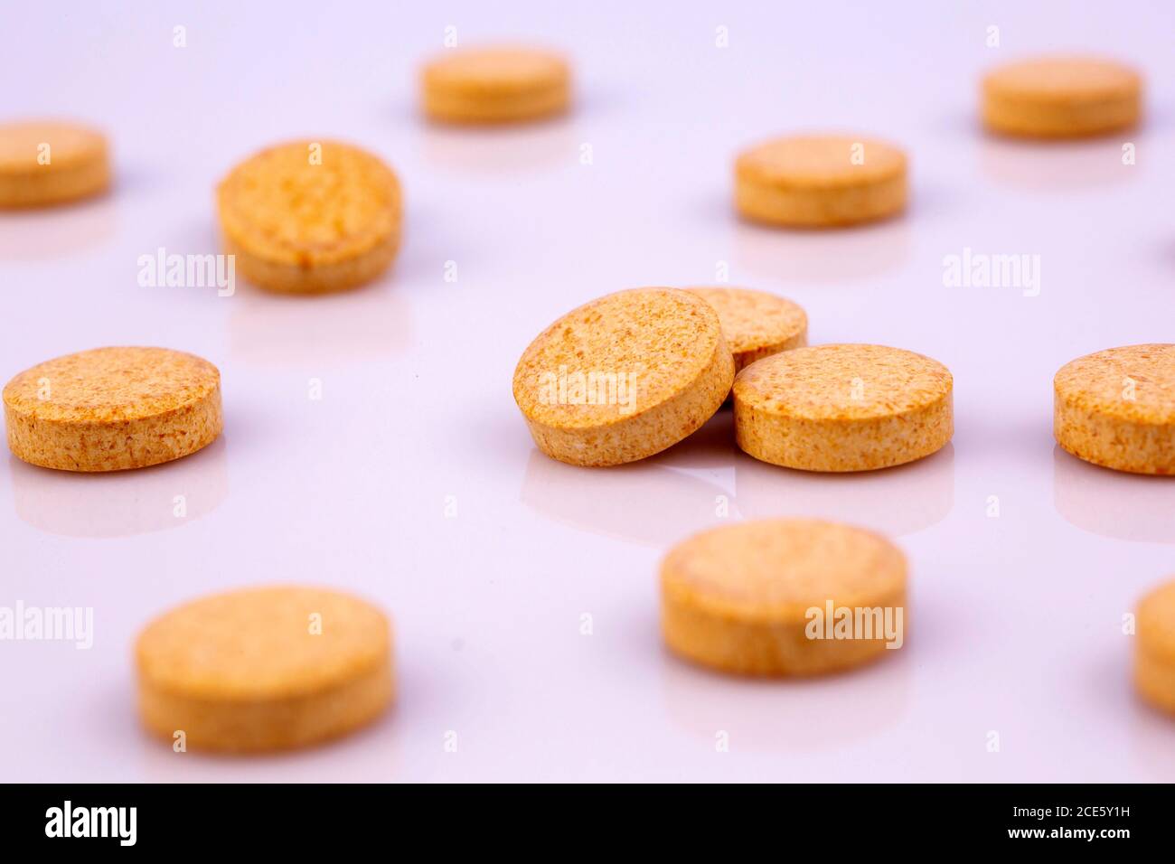 Beige pills isolated on white reflective background. Global ...