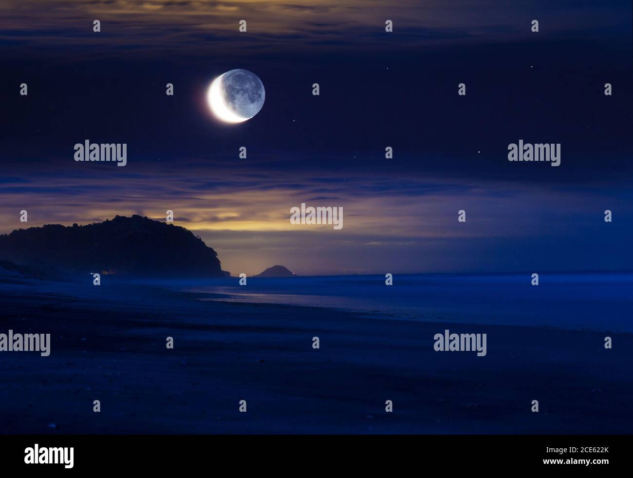 Full moon rising above ocean coast Stock Photo - Alamy