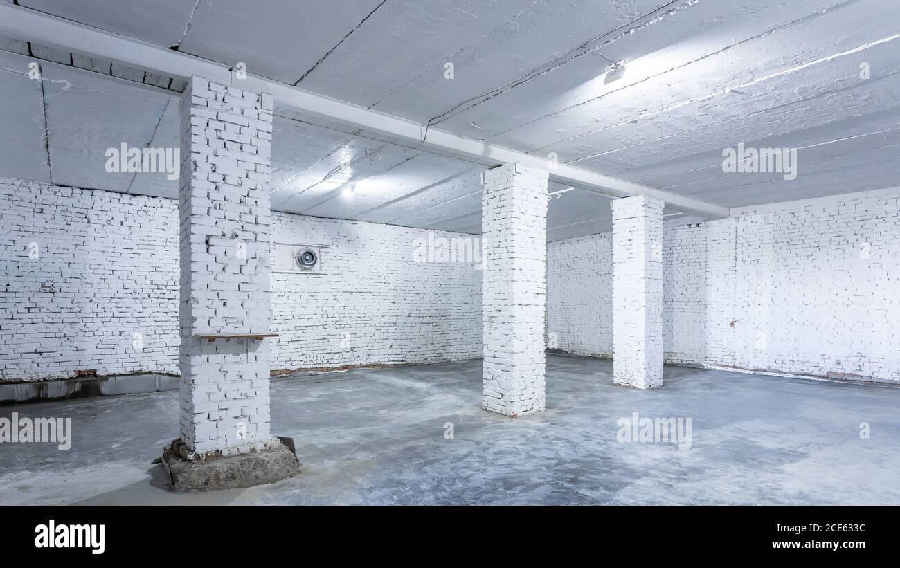 Industrial building interior with white brick walls, concrete floor and ...