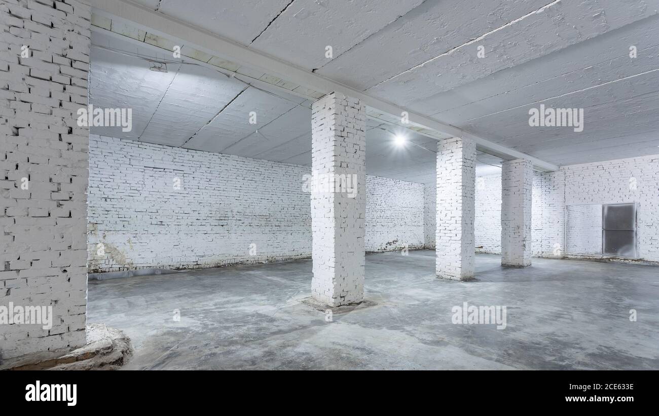 Industrial building interior with white brick walls, concrete floor and ...