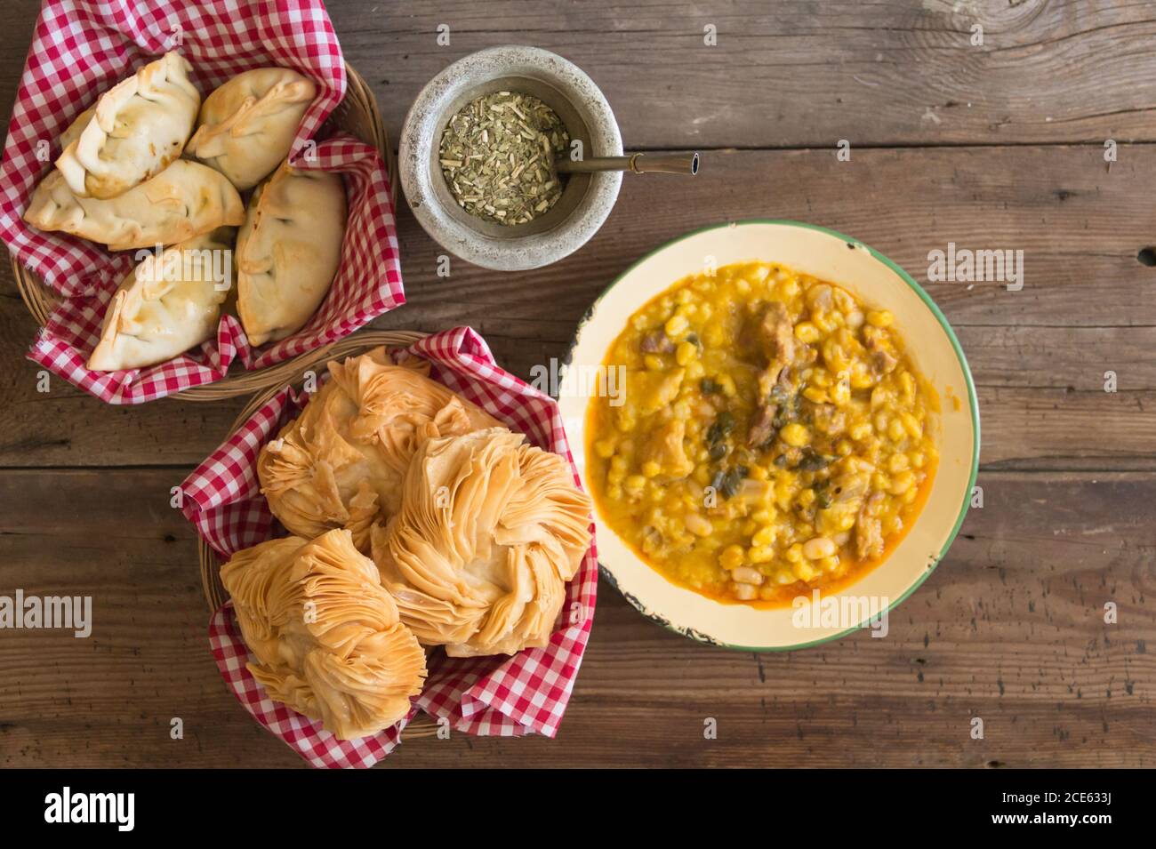 plate with empanadas, portion of locro, fried cakes and mate ...