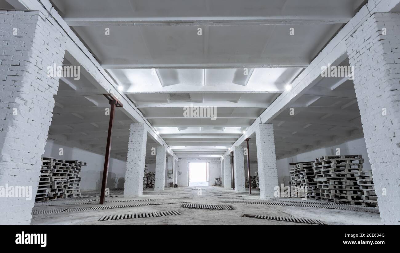 Industrial building interior with white brick walls, concrete floor and ...