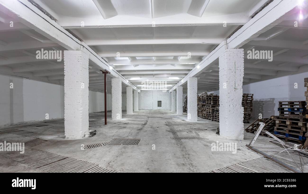 Industrial building interior with white brick walls, concrete floor and ...