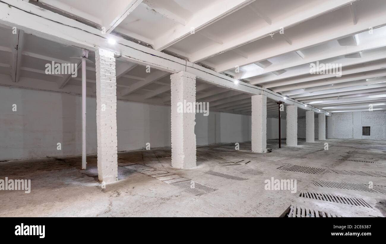 Industrial building interior with white brick walls, concrete floor and ...