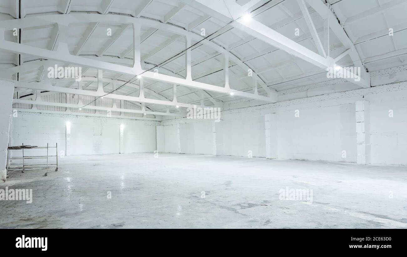 The interior of a huge industrial warehouse made of white bricks with a ...