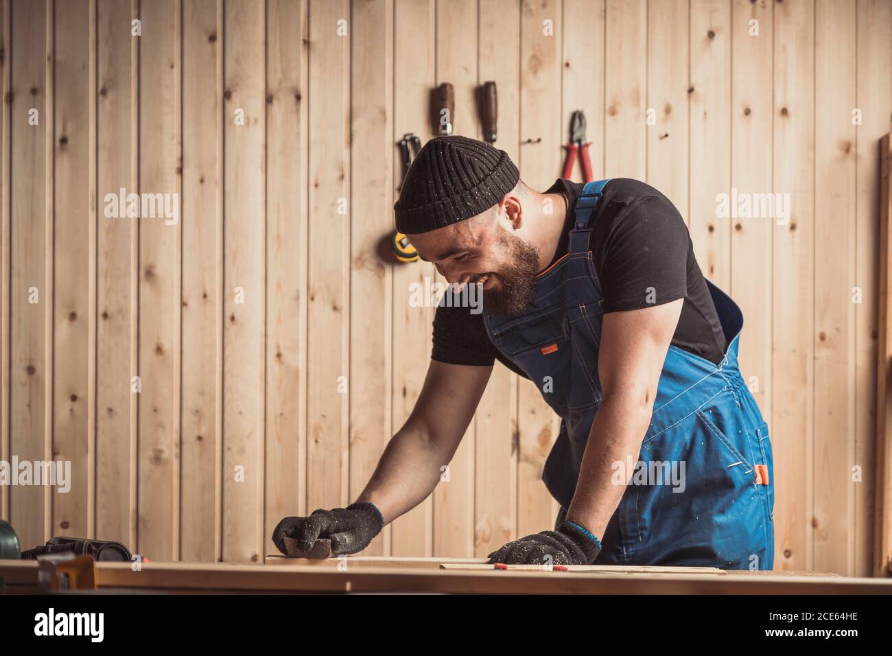 Experienced carpenter in work clothes and small buiness owner working ...