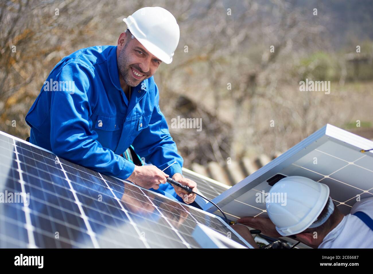 Male workers installing stand-alone solar photovoltaic panel system ...
