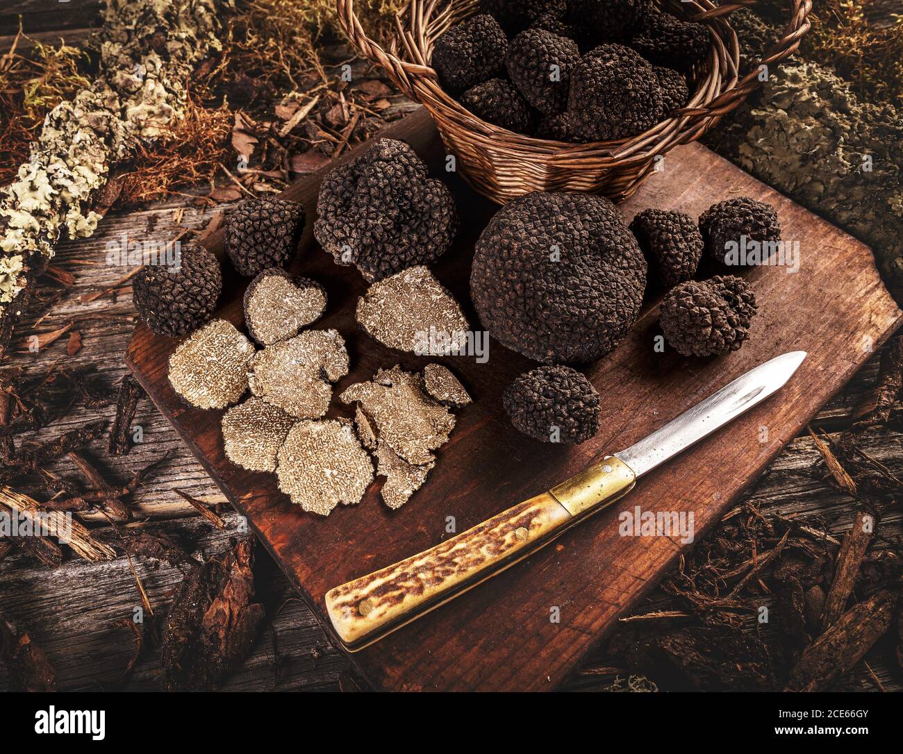 Black truffle with knife over rustic wooden cutting board Stock Photo ...