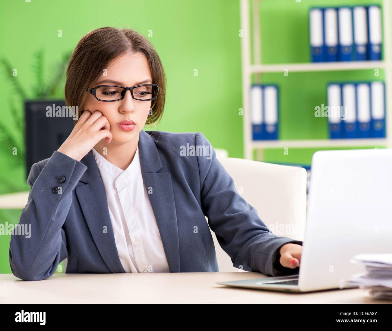 The young female employee very busy with ongoing paperwork Stock Photo ...