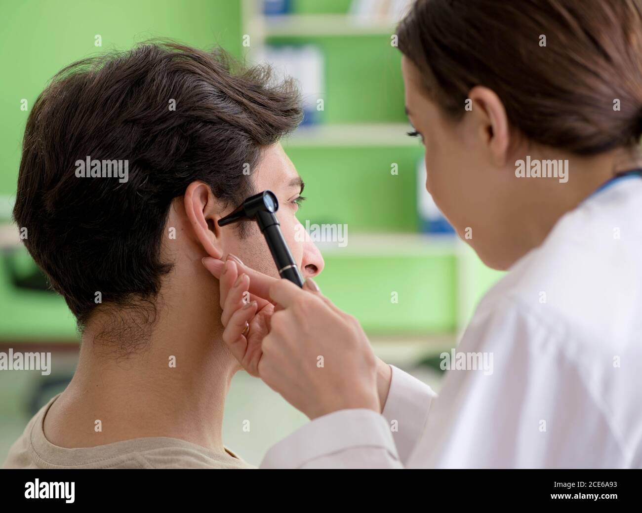 The female doctor checking patient's ear during medical examination ...