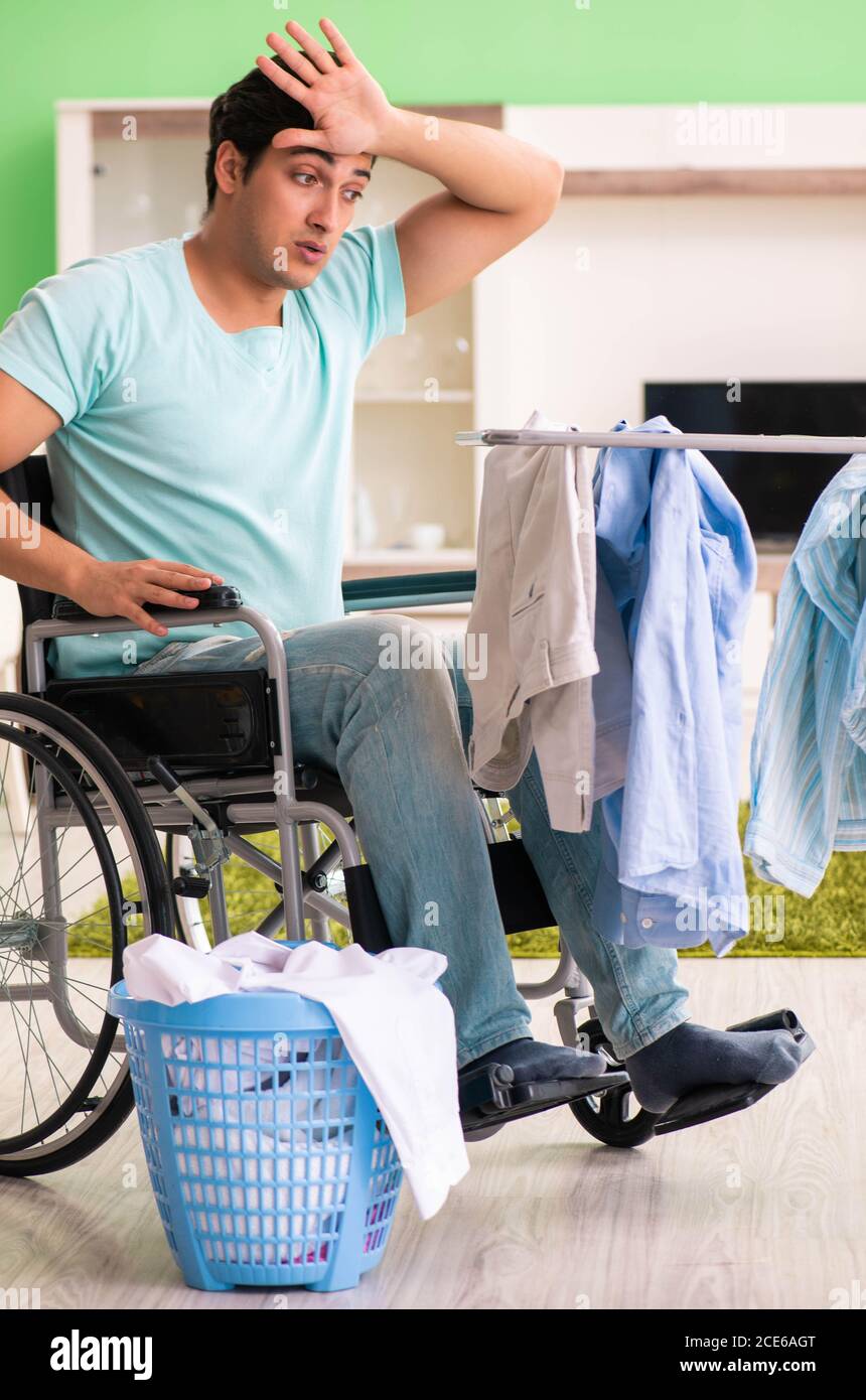 The disabled man on wheelchair doing laundry Stock Photo - Alamy