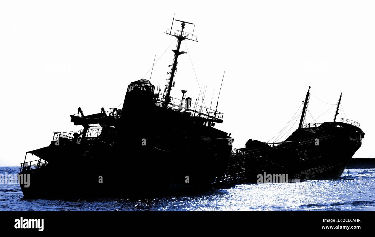 Silhouette of a ship that has run aground in shallow waters and is ...