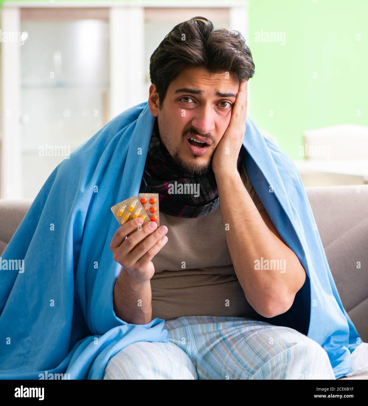 The sick young man suffering from flu at home Stock Photo - Alamy