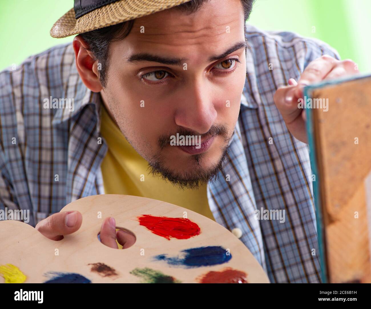 The young male artist working on new painting in his studio Stock Photo ...