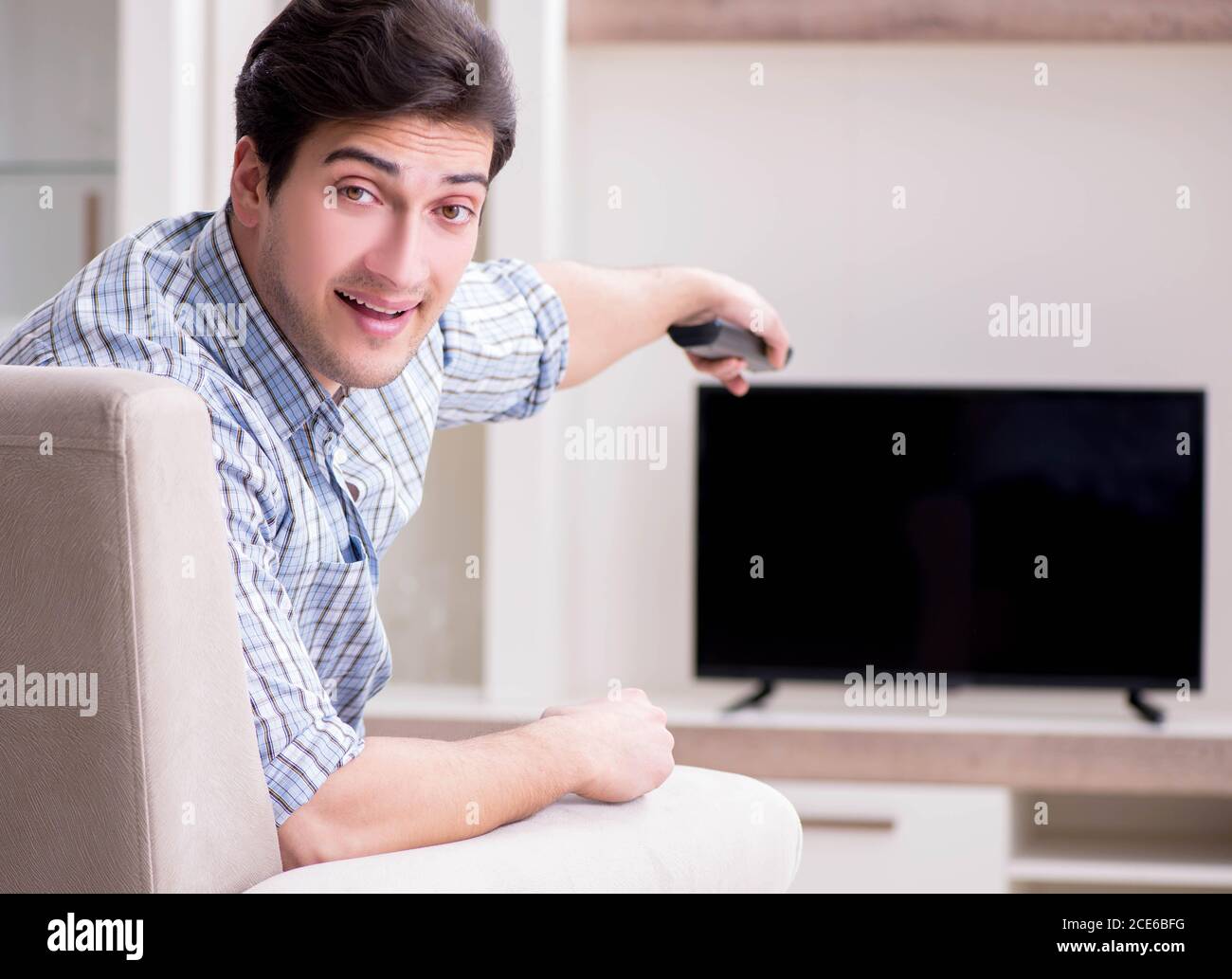 The young man watching tv at home Stock Photo - Alamy