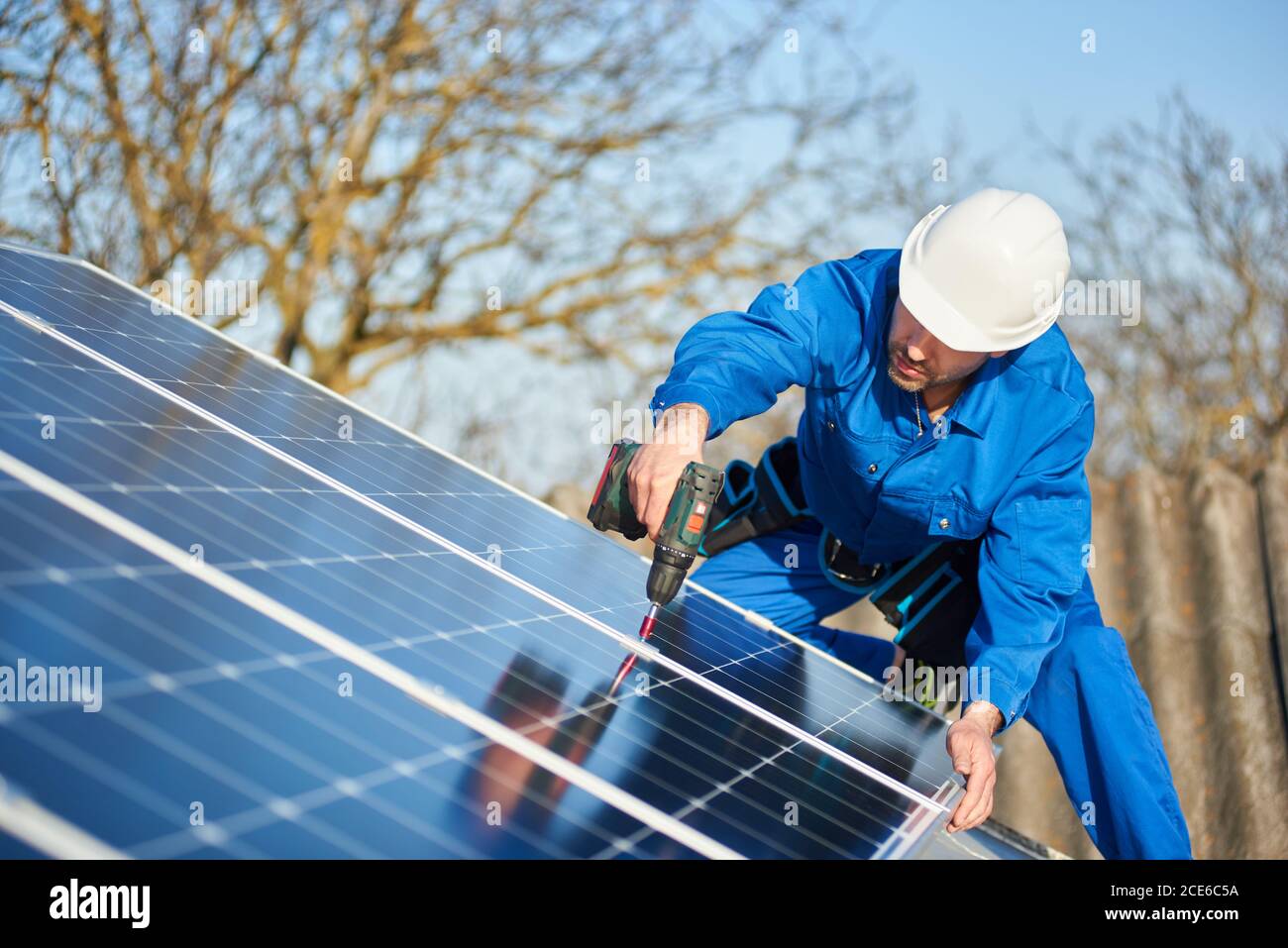 Man worker in blue suit and protective helmet installing solar ...