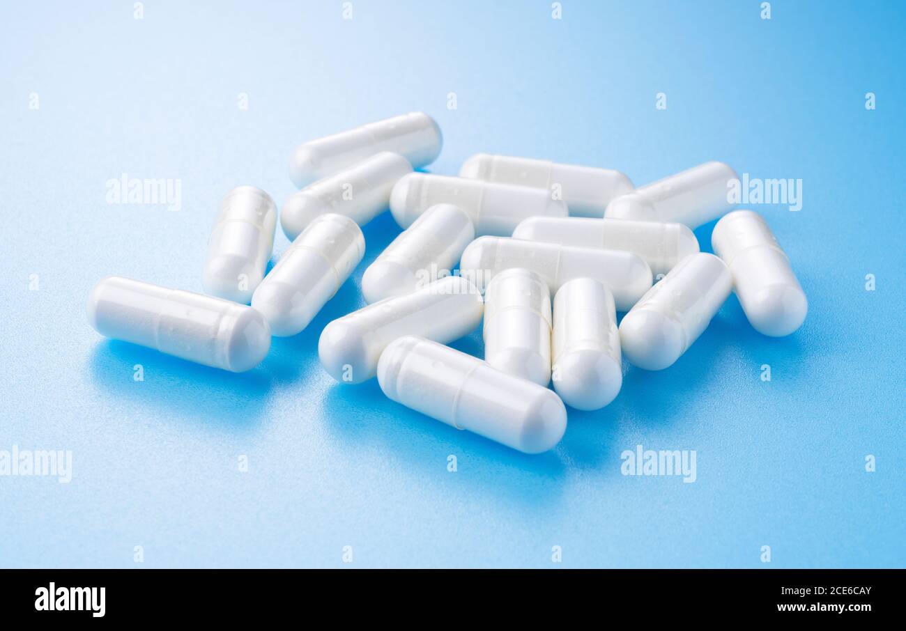 White capsules placed on blue background.Medical, health image Stock ...