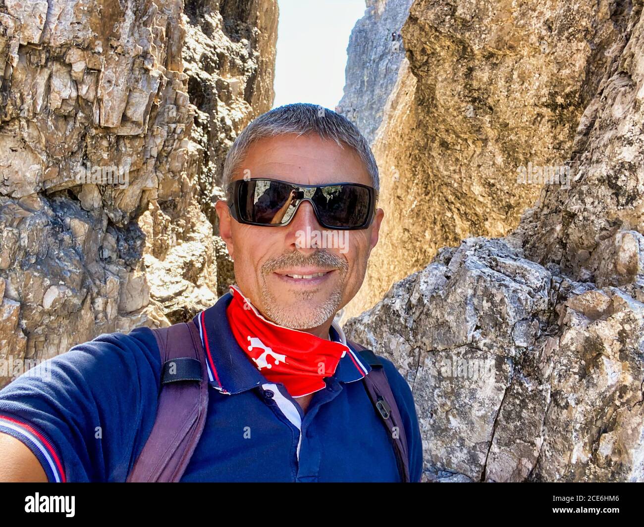 Happy man on a mountain excursion wearing health face masks during ...