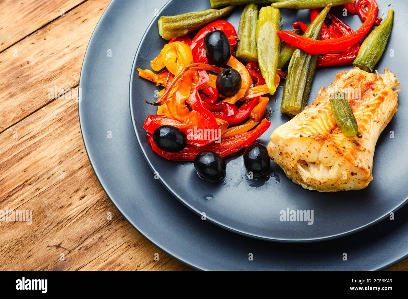 Fish grenadier baked with vegetables on wooden table.Seafood Stock ...