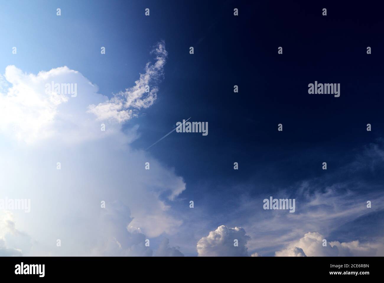 Airplane flying out of clouds Stock Photo - Alamy