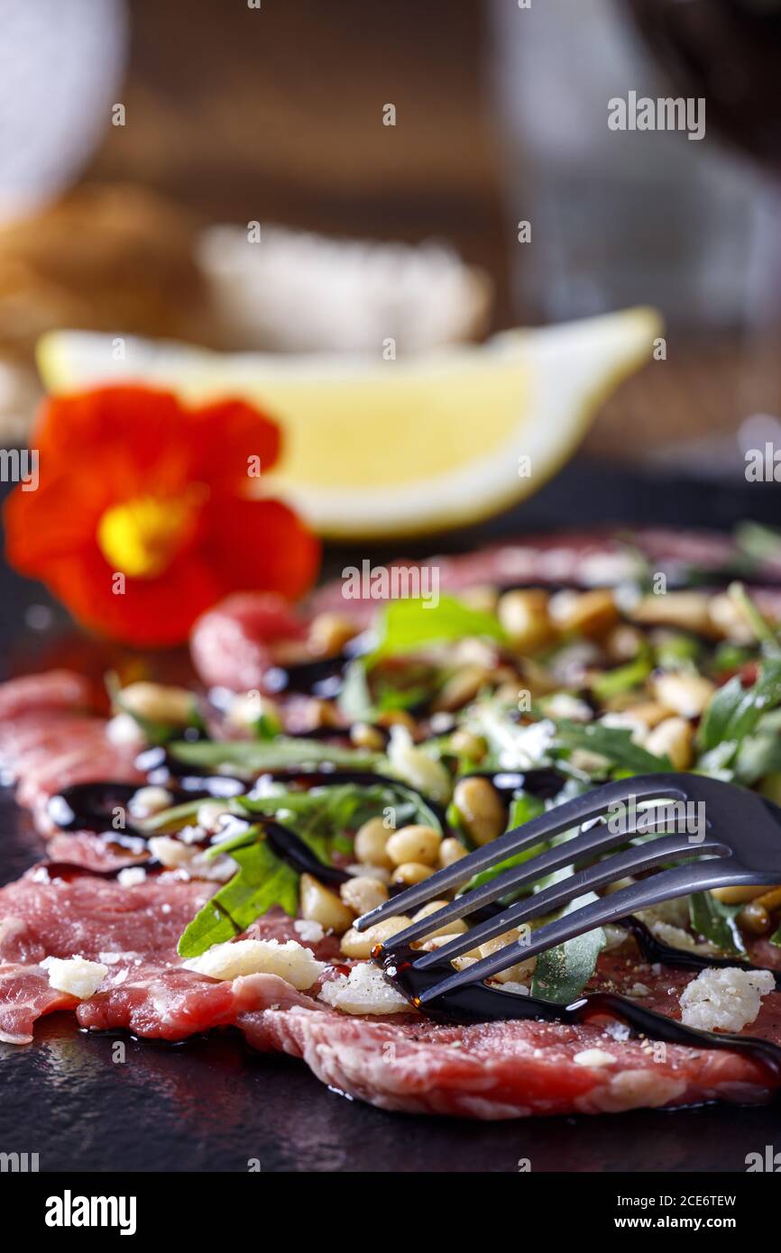 fresh carpaccio with rocket on slate Stock Photo - Alamy