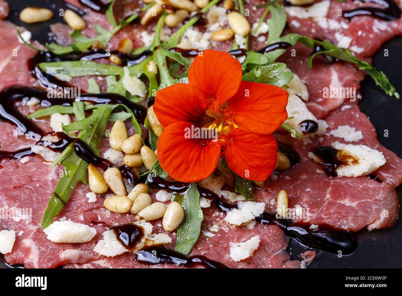 fresh carpaccio with rocket on slate Stock Photo - Alamy