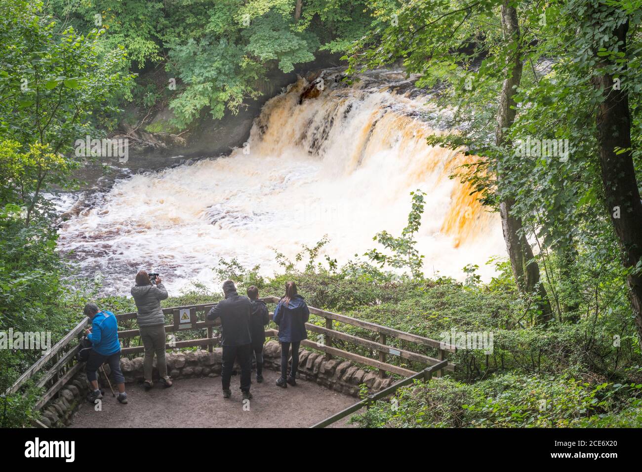 People photographing Aysgarth Falls with the river Ure in spate after ...