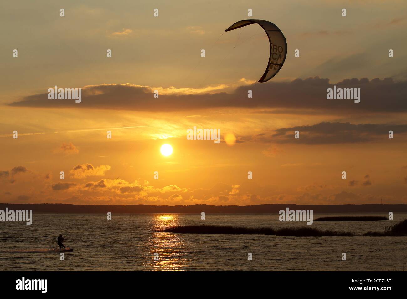 A power kite surfer swimming in the lagoon against the backdrop of a ...