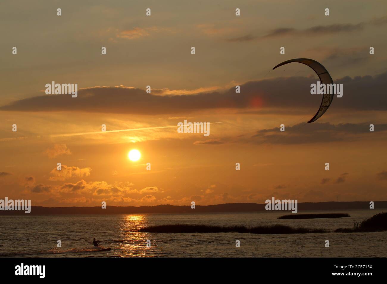 A power kite surfer swimming in the lagoon against the backdrop of a ...