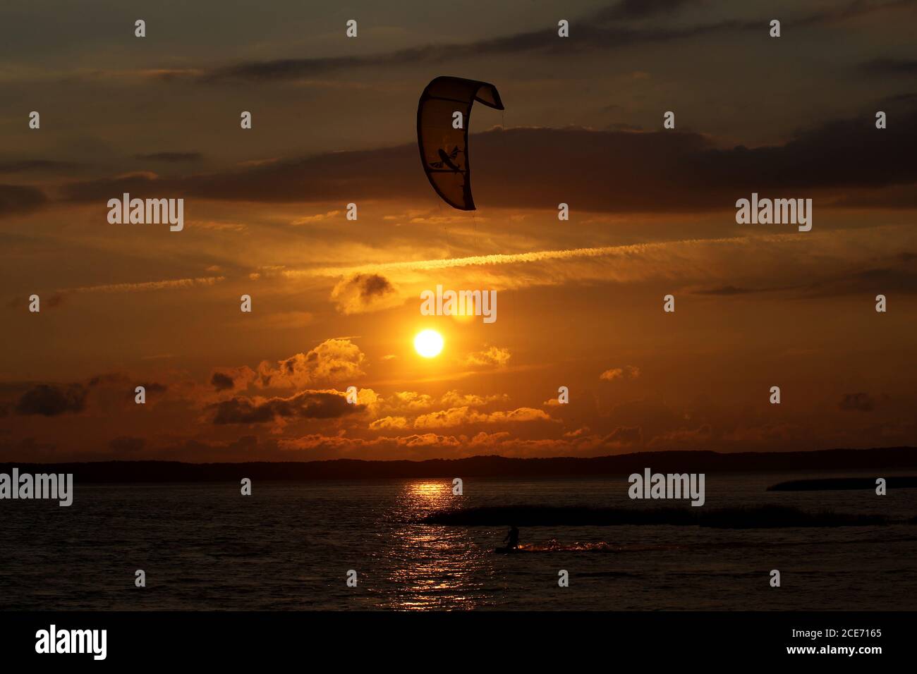 A power kite surfer swimming in the lagoon against the backdrop of a ...