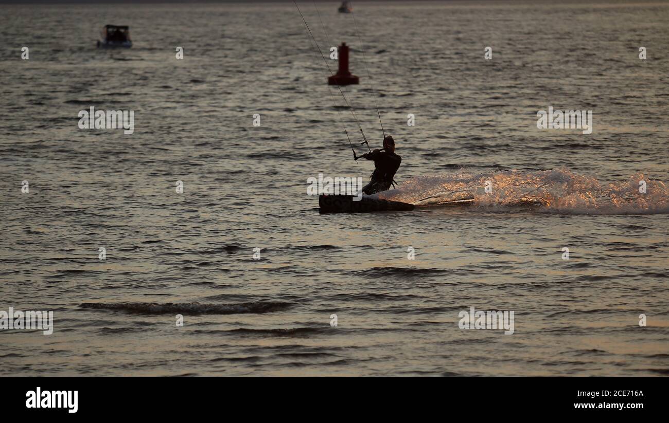A power kite surfer swimming in the lagoon against the backdrop of a ...