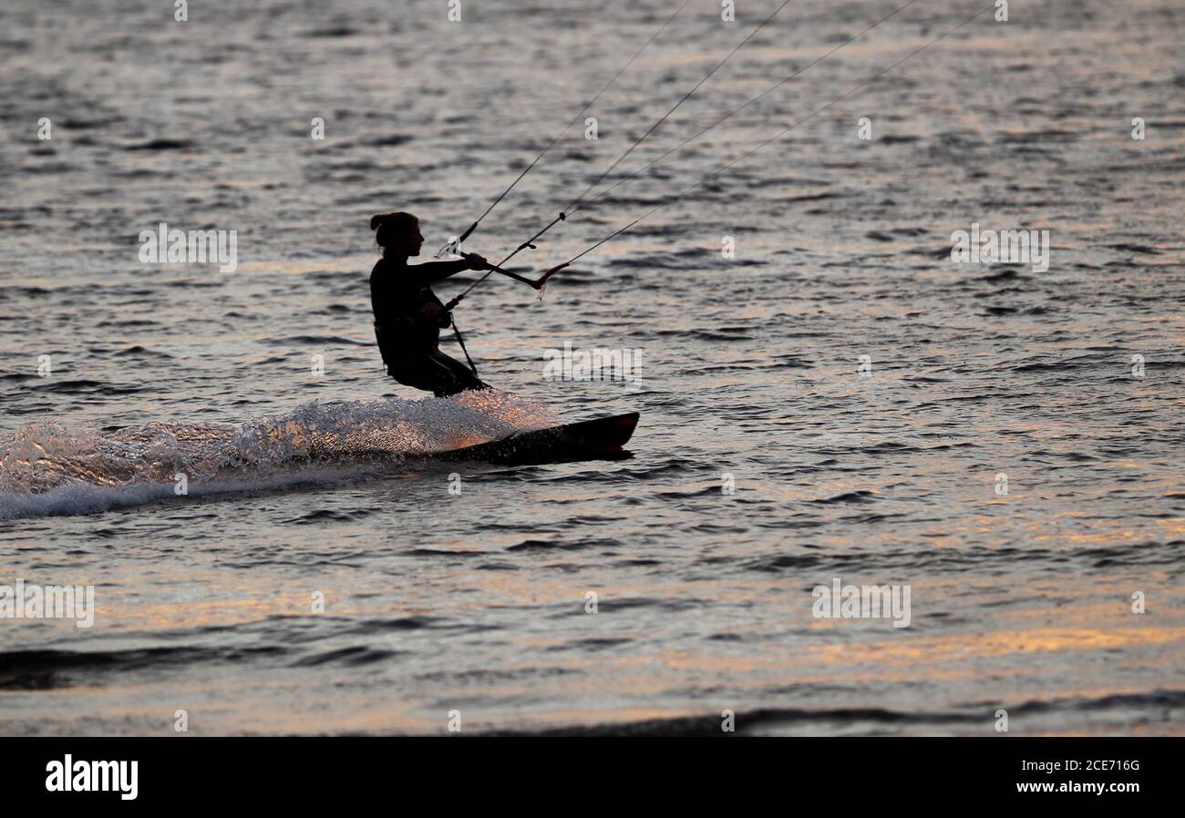 A power kite surfer swimming in the lagoon against the backdrop of a ...