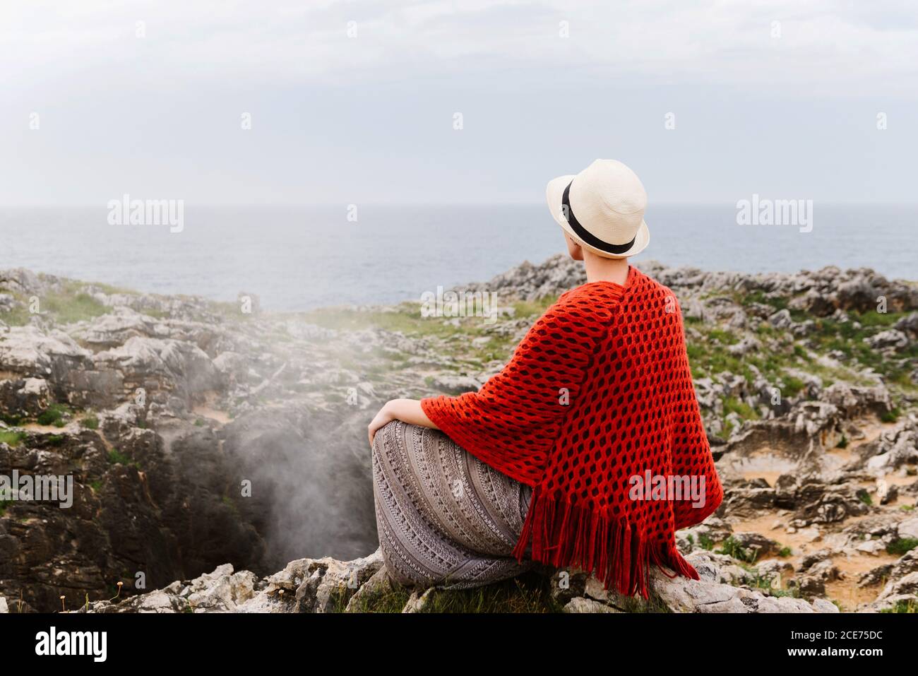 Back view of unrecognizable female traveler in stylish knitwear and hat ...